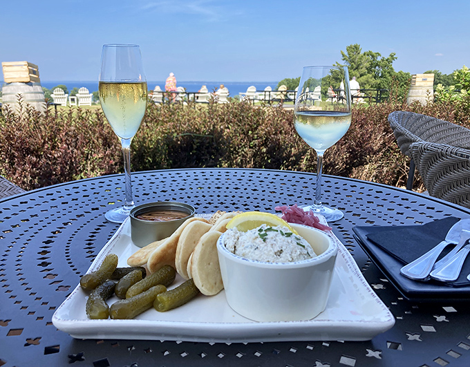 A perfect Michigan moment captured &ndash; local delicacies and sparkling wine create an impromptu celebration against a backdrop of vineyard and water views.