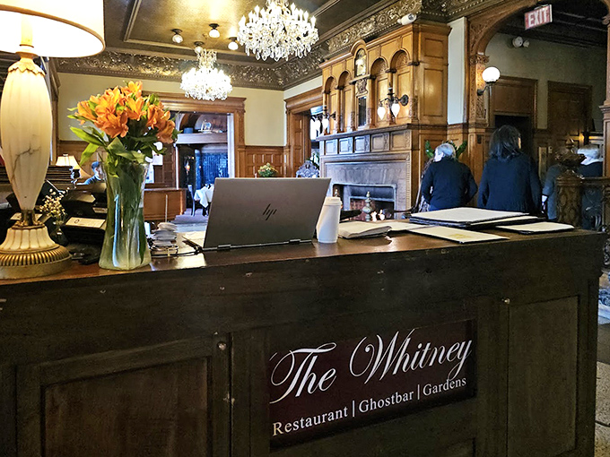 The elegant reception desk welcomes guests into The Whitney's world of historic charm, where modern hospitality meets Gilded Age grandeur.