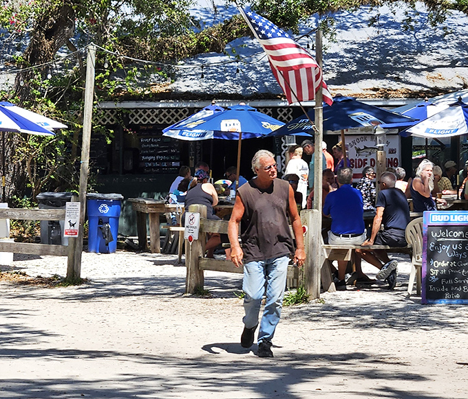 Locals and visitors mingle under blue umbrellas, united by their quest for authentic Old Florida flavor.