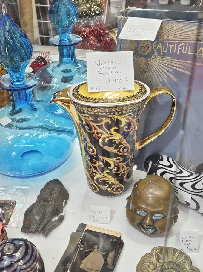 This elegant Versace teapot sits regally among blue decanters, waiting for someone who appreciates afternoon tea served with style.