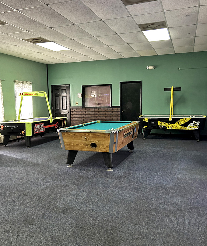 The game room offers nostalgic entertainment with pool tables and arcade games, where waiting for food becomes part of the experience.