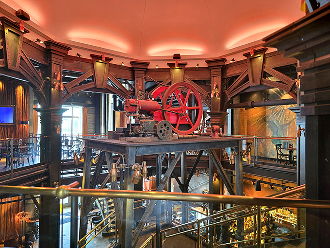 A massive red flywheel commands attention from its mechanical throne, a steampunk centerpiece that keeps the restaurant's industrial heart beating visibly for all guests.