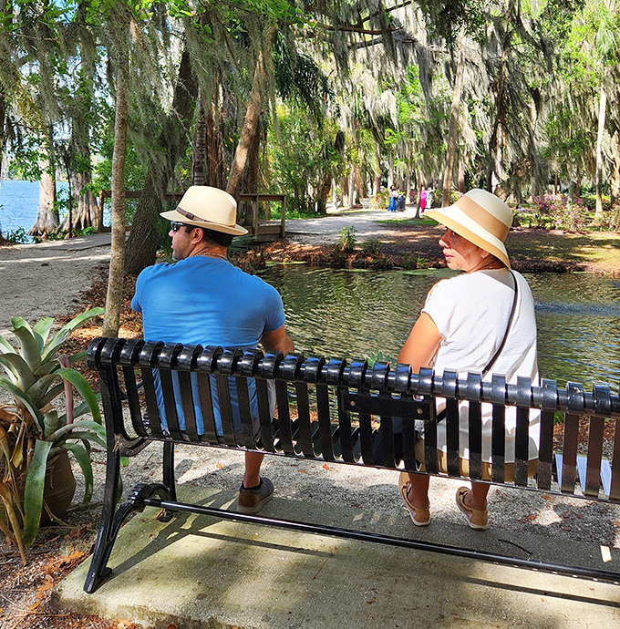 Visitors in straw hats soak in the tranquility, proving sometimes the best vacation moments happen on a simple park bench.