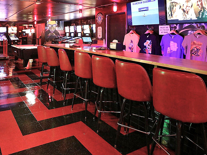 Red stools line up like lives waiting to be played, offering front-row seats to the mixology magic happening behind the counter.