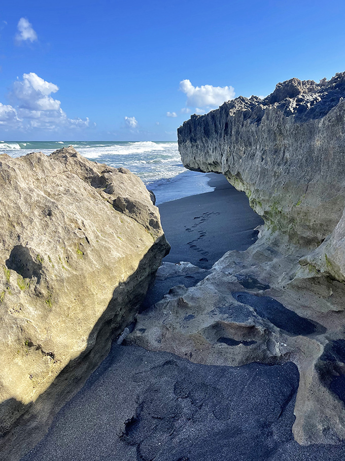 Shadows play across this narrow passage between towering rocks, creating a cathedral-like atmosphere with the sky as ceiling.