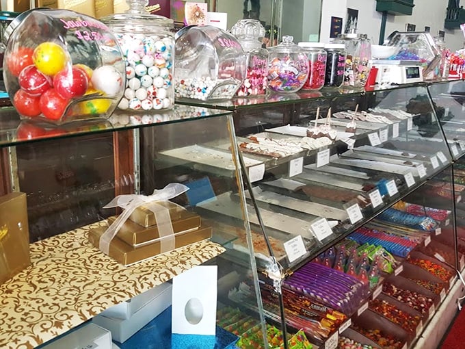 Candy Display Counter: A glass-fronted wonderland where willpower goes to die &ndash; each shelf offering a different path to sweet satisfaction.