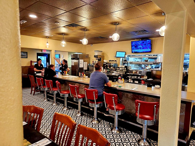Red stools invite diners to belly up to the counter, where coffee flows freely and breakfast chatter creates the perfect morning soundtrack.