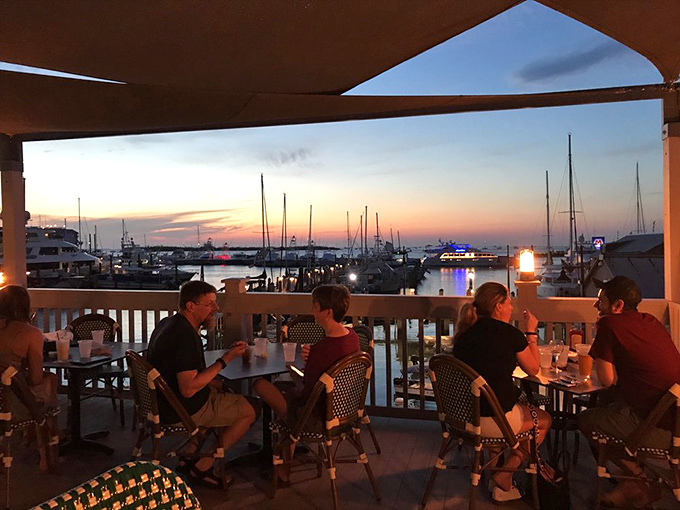As sunset paints the harbor gold, diners settle in for that magical hour when food tastes better and conversations flow easier.