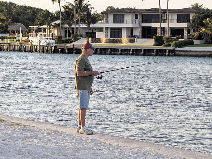 An angler casts his line with patient optimism, part of the timeless dance between human and fish that defines coastal Florida living.
