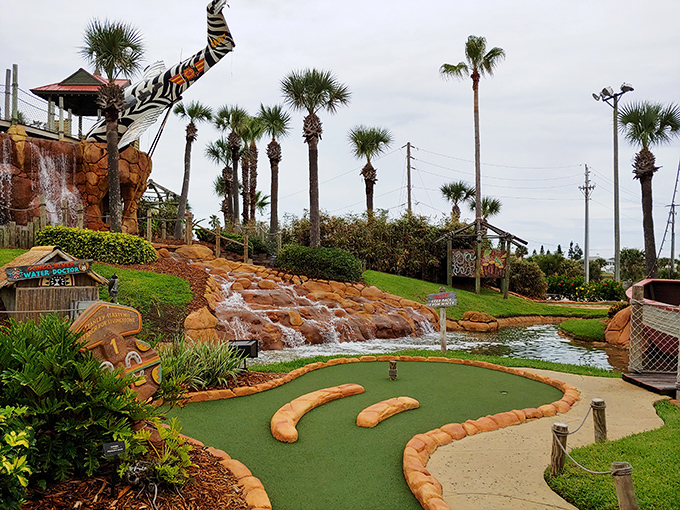 Water cascades dramatically over carefully positioned rocks, creating both a stunning visual centerpiece and the soothing soundtrack to your putting adventure.