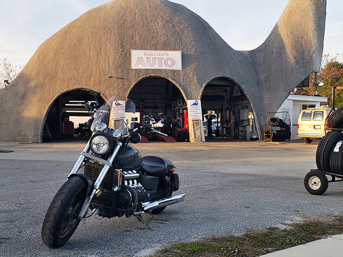 Even motorcycles look right at home outside this prehistoric garage, adding another layer to this transportation time warp.