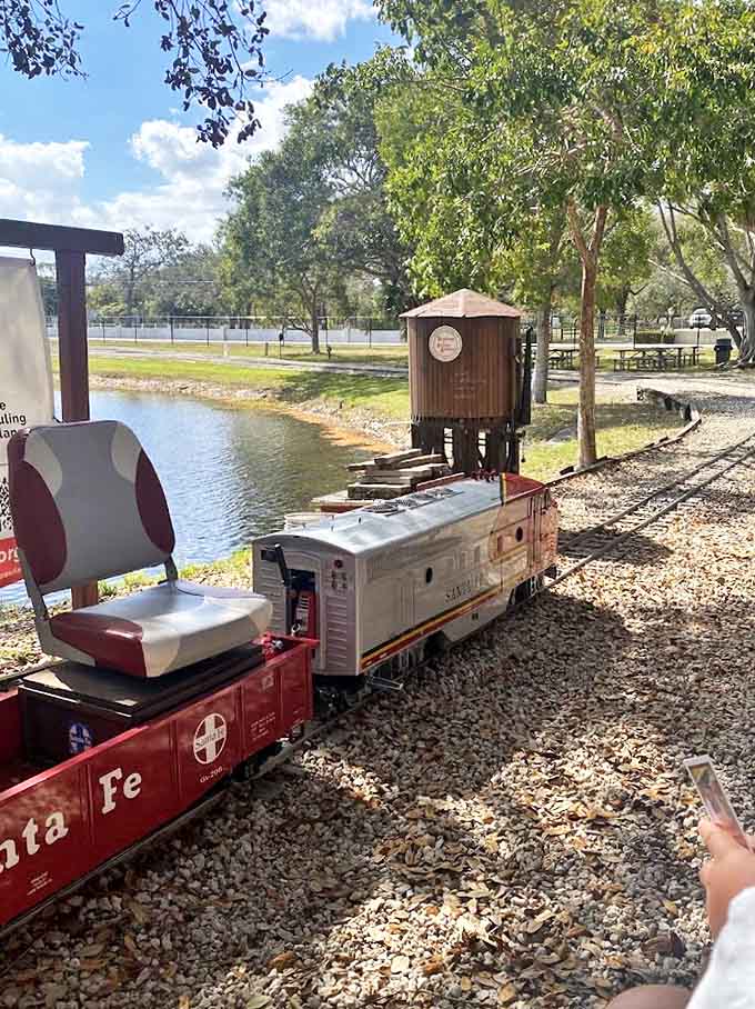 The Santa Fe miniature train glides alongside the water, carrying passengers on a journey that's more about joy than destination.