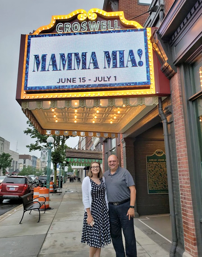 Theatergoers pose beneath the iconic Mamma Mia! marquee, creating memories that will last long after the final curtain call.