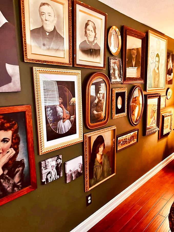 The gallery wall of vintage portraits creates the uncanny feeling that you're being watched from every angle. Each frame holds a different story.