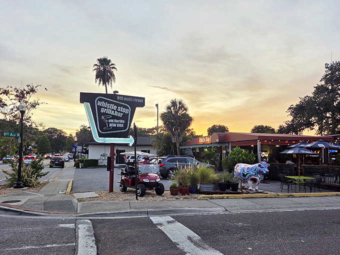 The Whistle Stop's vintage sign glows against a sunset sky, beckoning hungry travelers with promises of comfort food and local flavor.