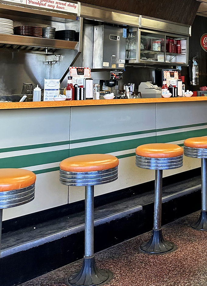 Classic counter seating invites solo diners to enjoy front-row views of short-order cooking magic while swiveling with childlike delight.