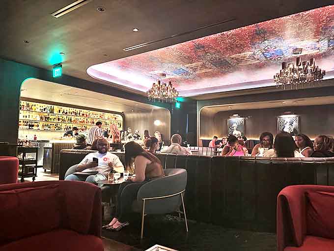 By night, the space transforms into an intimate lounge where conversations flow as smoothly as the expertly crafted cocktails.