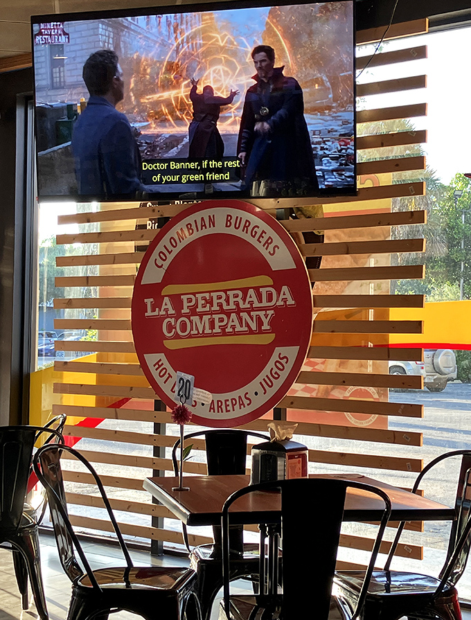 Even superheroes on the TV seem impressed by La Perrada's bold claim as "Home of the Original Colombian Burger."