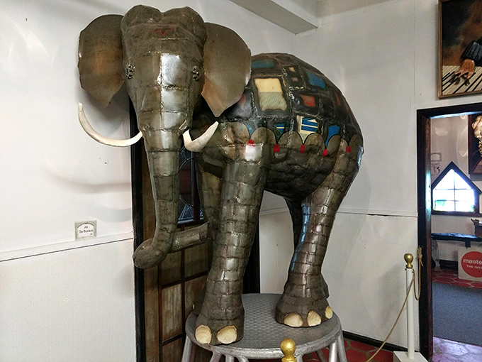 This metallic pachyderm proves that even elephants look more dignified when dressed in stained glass and recycled materials.