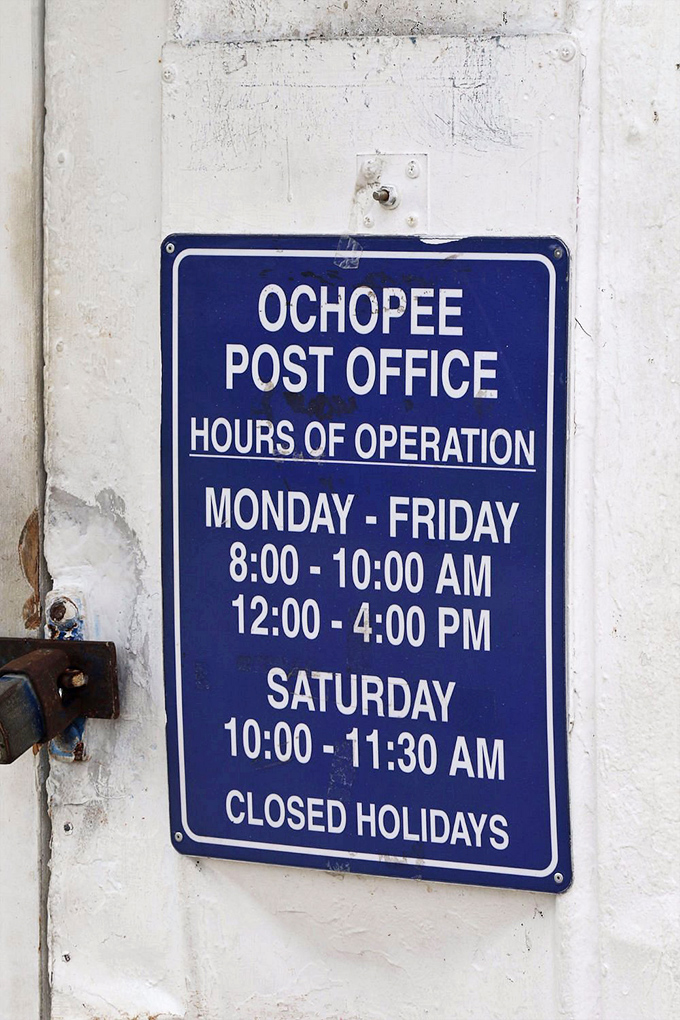 The hours of operation sign reveals the rhythms of postal life in Ochopee – a schedule as compact as the building itself.