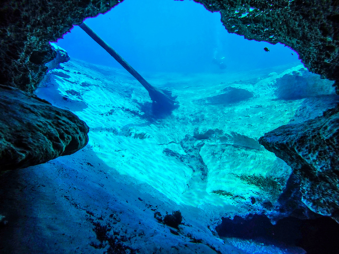 Looking up from underwater caves reveals nature's perfect light show, as sunbeams filter through the spring water creating ethereal "God rays."