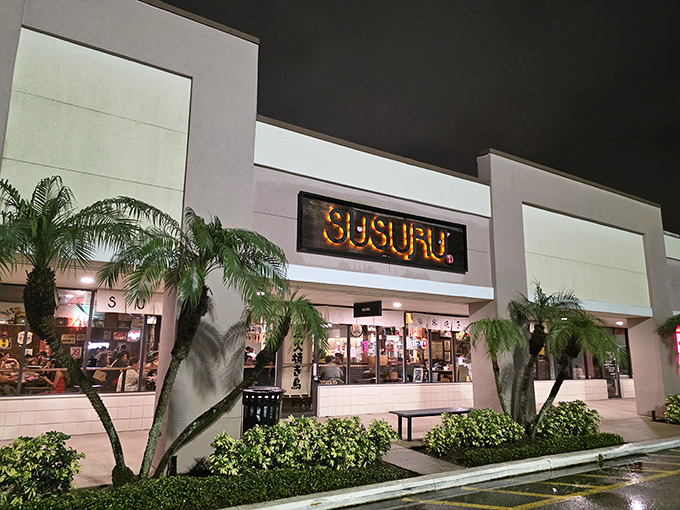 The illuminated SUSURU sign glows invitingly, promising authentic Japanese street food with a side of retro pop culture.