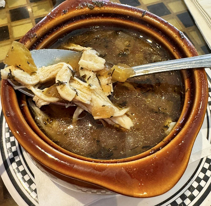 This isn't some thin, apologetic soup – it's liquid comfort in a crock, with chunks of chicken and vegetables swimming in golden broth.