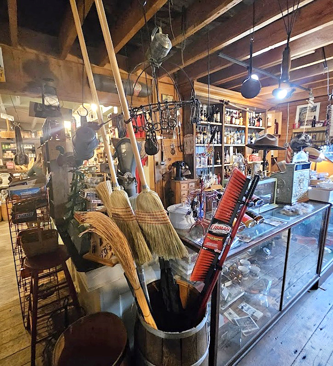 Practical cleaning tools stand ready in wooden barrels &ndash; corn-husk brooms and sturdy brushes made for serious work rather than decorative display.