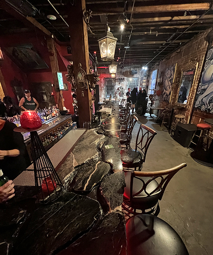 The dramatic bar counter, carved from what appears to be solid stone, serves as both functional space and artistic statement in The Castle's carefully crafted environment.