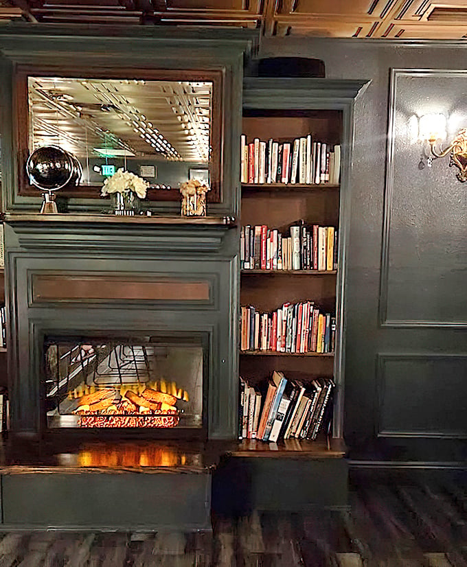 A crackling fireplace flanked by bookshelves creates the ultimate reading nook &ndash; just add a well-crafted cocktail for peak cozy sophistication.