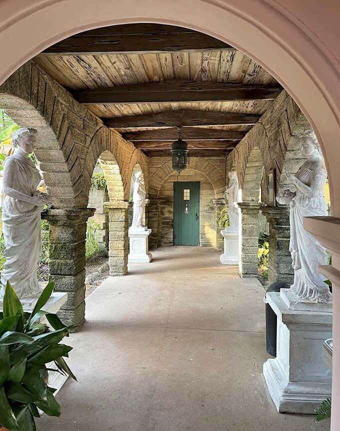 Sunlight streams through the arched colonnade, creating dramatic shadows that dance across stone and statuary in this architectural gem.