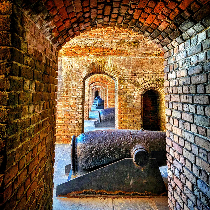 Inside the historic Fort Zachary Taylor: Brick tunnels frame ancient cannons, creating a photographer's dream of symmetry and history.