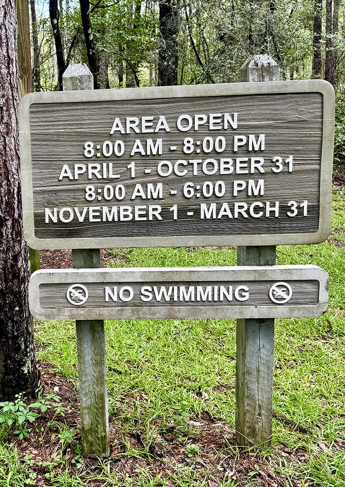 The operation hours sign politely reminds visitors that even Mother Nature needs some alone time&mdash;and swimming in sinkholes is never a good idea.