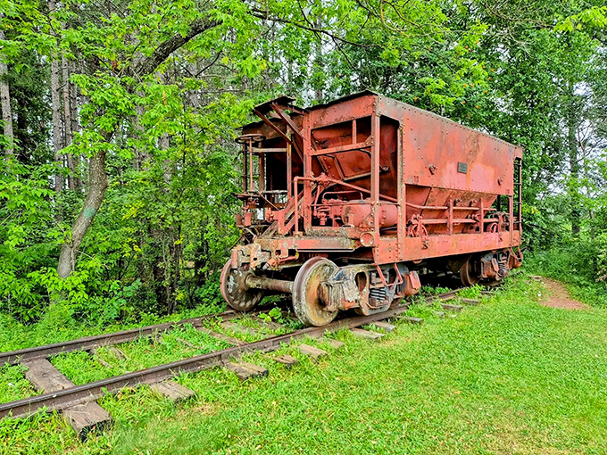 An authentic ore car on display near Hiawatha connects visitors to Ironwood's mining heritage, rusting gracefully among the greenery like an industrial sculpture.