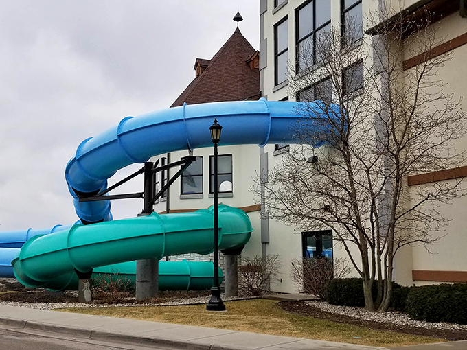 Blue water slides emerge from the building like escaped roller coasters, teasing the thrills waiting inside.