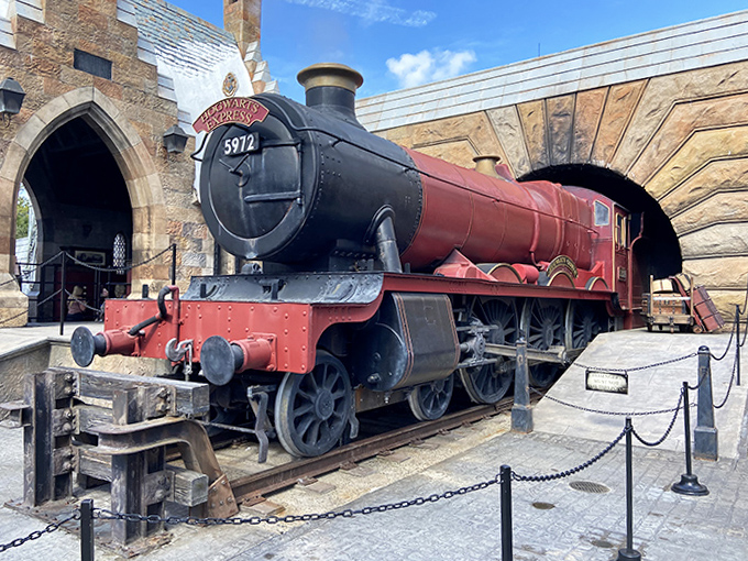 The magnificent steam engine rests between journeys, its mechanical details showcasing Universal's commitment to authentic craftsmanship.