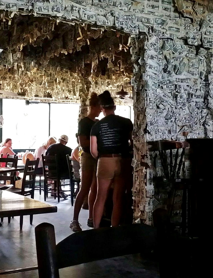 Patrons enjoying the unique atmosphere where walls of money create a backdrop for conversations and meals that become cherished vacation memories.