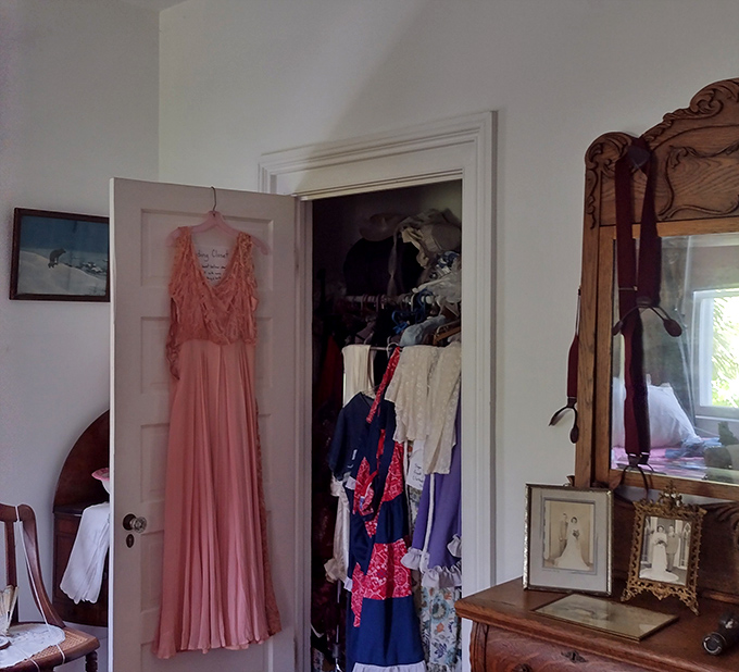 That pink dress hanging expectantly speaks volumes &ndash; its delicate fabric and intricate details showcase an era when even everyday clothing required artistic craftsmanship.