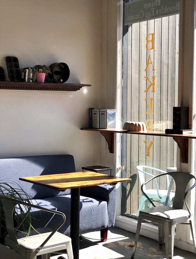 Sunlight streams through the window, illuminating a peaceful nook where coffee and conversation flow as freely as the icing.