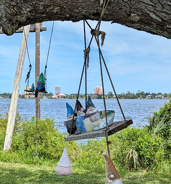 Gnomes of all shapes, sizes, and styles create a colorful tapestry against the tree's natural bark.