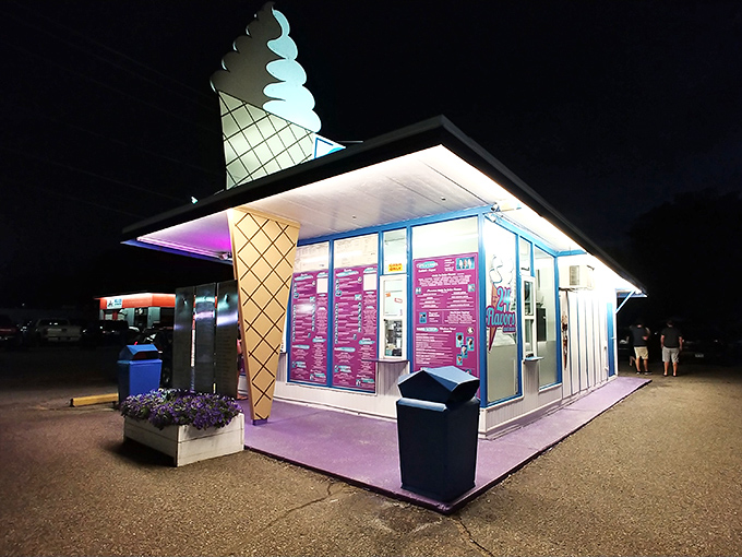 As evening falls, Custard Spot transforms into a glowing dessert oasis, its neon signs beckoning sweet-toothed night owls from miles around.