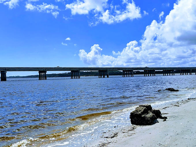 The bridge stretches across calm waters under brilliant blue skies, connecting visitors to this pristine natural sanctuary.