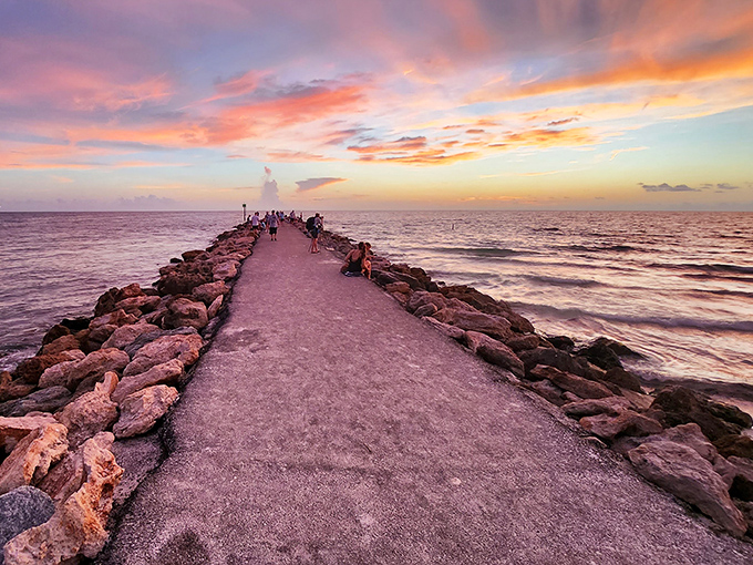 The North Jetty stretches toward infinity, where fishermen and philosophers find common ground watching the horizon.