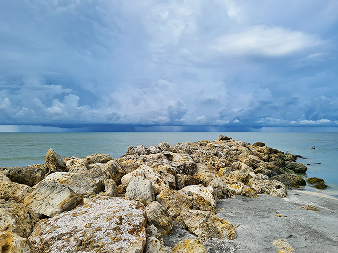 Natural rock formations create tide pools where smaller marine creatures find refuge and shell hunters discover hidden treasures.
