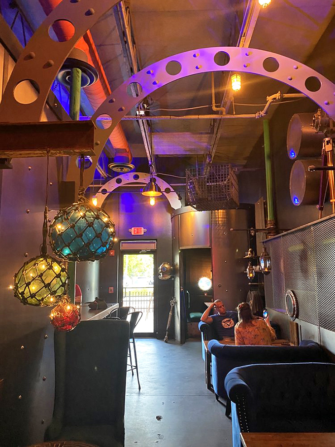 Navy blue tufted couches and industrial metal accents create seating areas that are somehow both Victorian and futuristic at once.