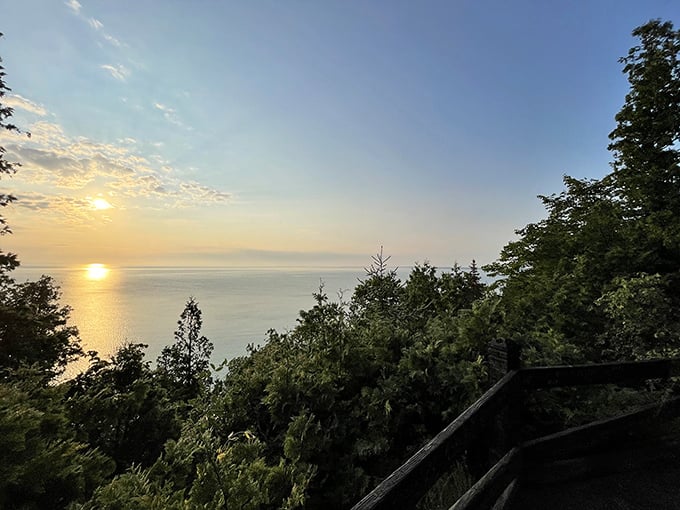 Sunset casts golden light across Mackinac Island, turning Lake Huron into a shimmering copper sea beneath the darkening sky.