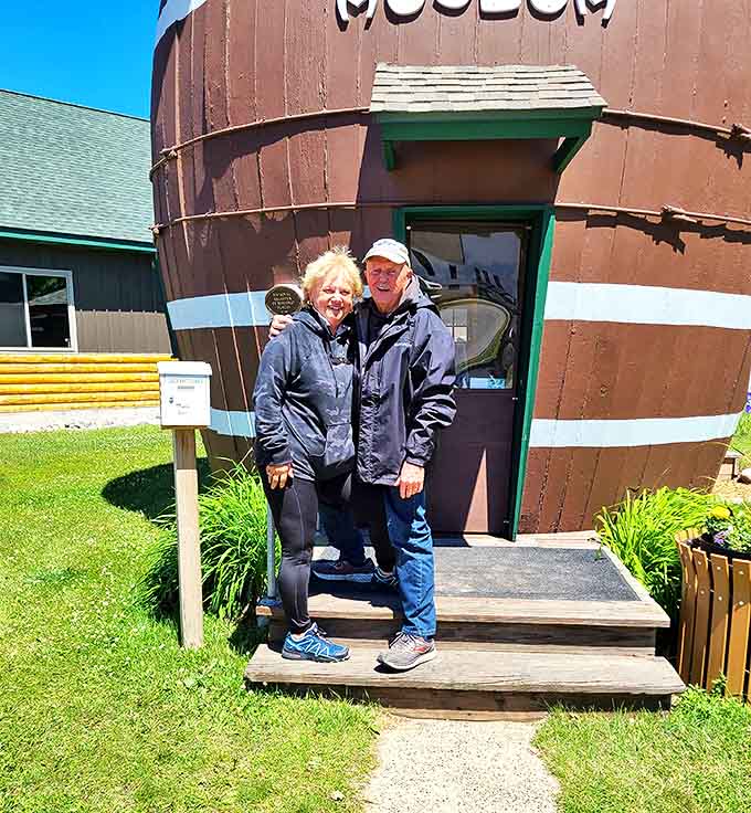 Happy visitors pose at the entrance, joining the countless others who've stood here wondering if they're really about to tour a pickle barrel.