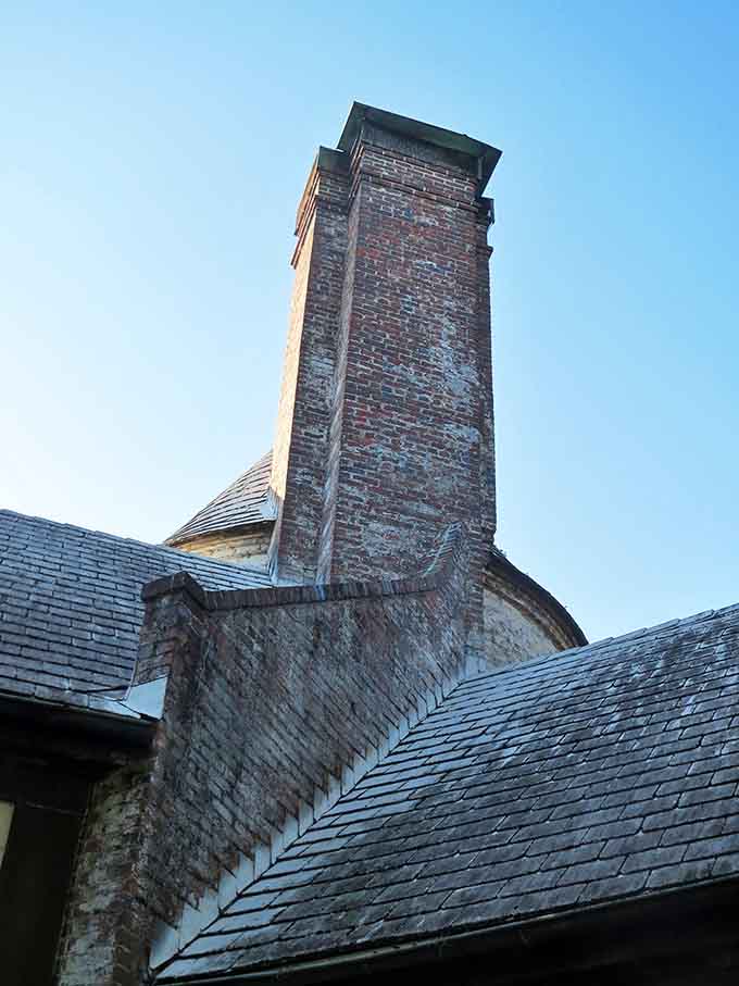 The chimney reaches skyward, a brick exclamation point punctuating the mansion's silent story of grandeur, abandonment, and the passage of time.