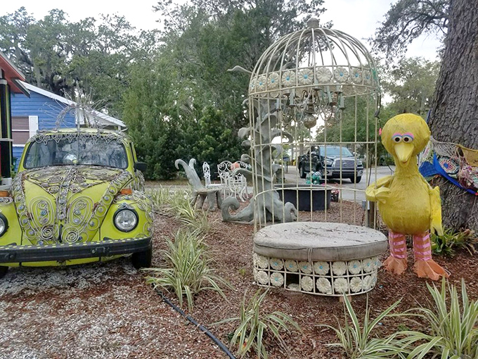 Whimsy on wheels: between the decorated VW Beetle and the giant yellow bird, this entrance scene sets the tone for the delightful absurdity within.