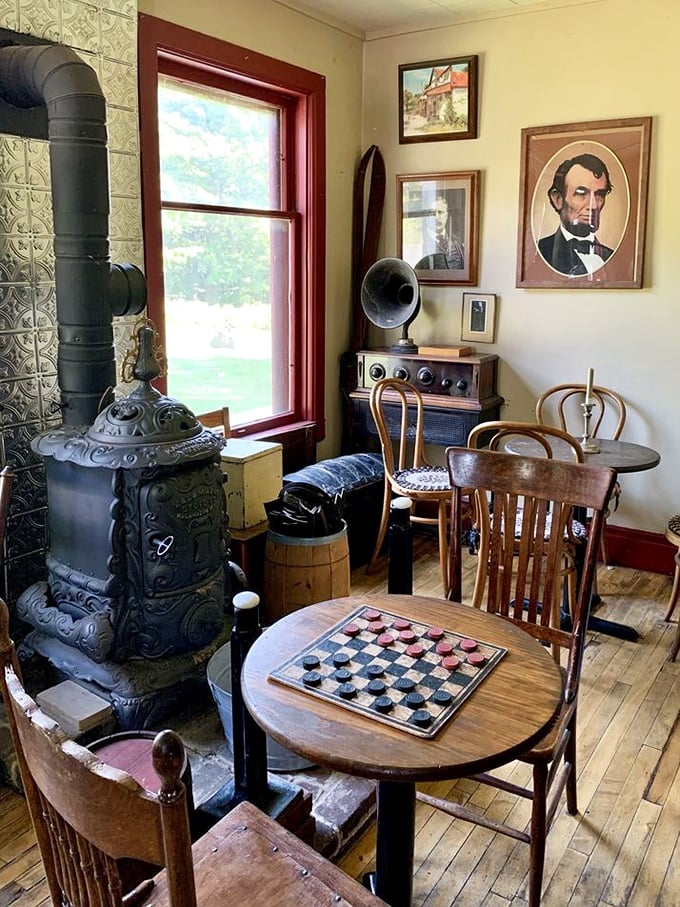 A checkerboard waits for players beside a potbellied stove, while Abraham Lincoln's watchful gaze approves of this preservation of his era.